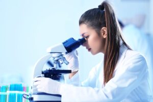 woman looking in microscope - Wyoming Department of Health