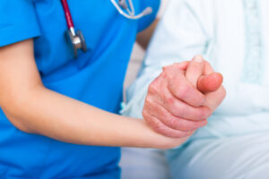 nurse holding patient hand - Wyoming Department of Health